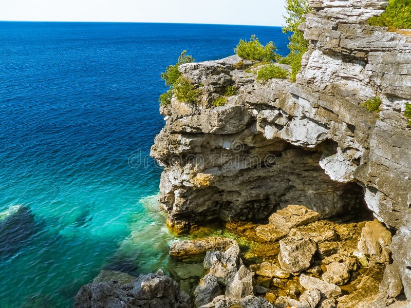 Rocky Grotto Over Turqoise Blue Water Stock Image - Image of clean ...