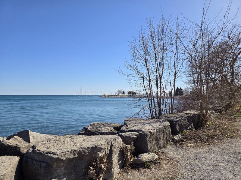 Rocky Lakeshore with Bare Trees and Distant Peninsula Stock Photo ...