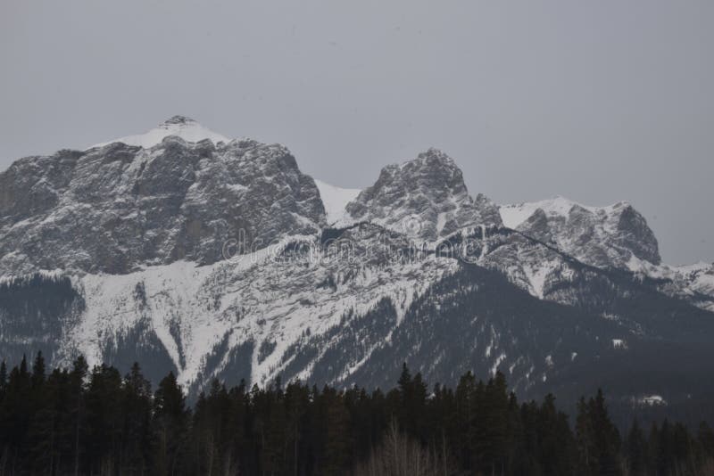 Snow Covered Rocky Mountains with Hazy Grey Sky Stock Image - Image of ...
