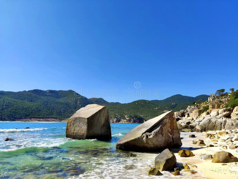 A Rocky Sandy Beach with Large Massive Big Rock Boulder in the Water ...