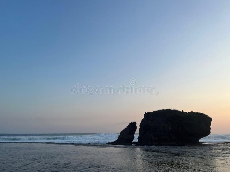 A Rocky Shoreline with a Large Rock in the Foreground Stock Image ...