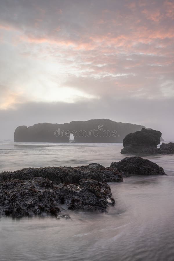 A Rocky Shoreline with a Large Rock Formation in the Foreground Stock ...