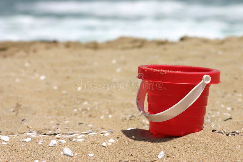 Rode speelgoed strandemmer stock foto. Image of zomer, water - 22566