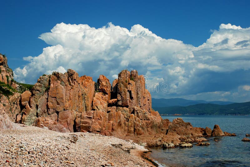 Rode rots op het strand stock afbeelding. Image of blauw - 3843259