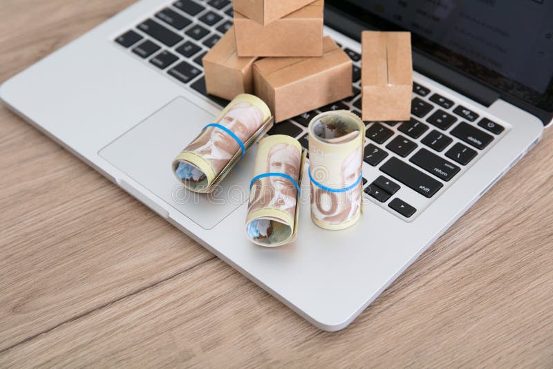 A Roll of Canadian Dollar Bills and a Courier Box Model are Placed on ...