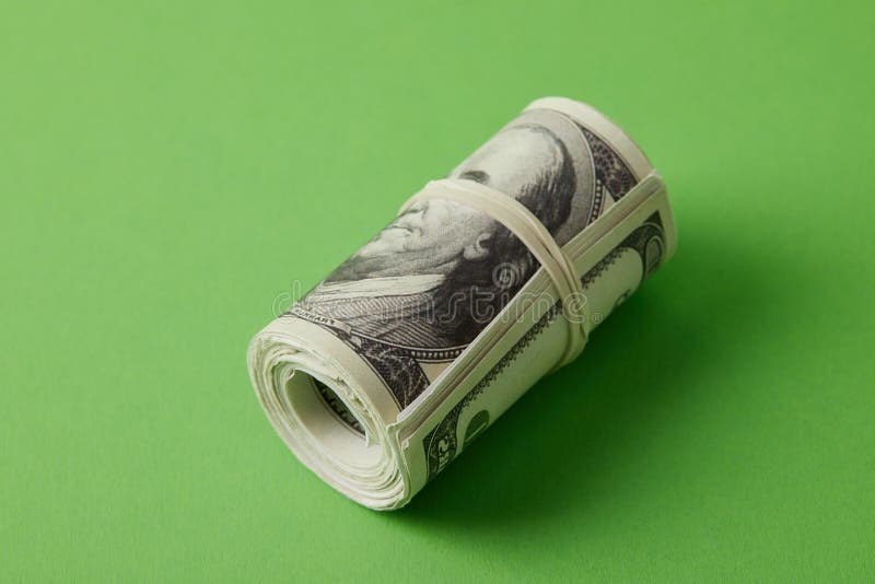 Roll of Dollars Tied with Rubber Band on Green Surface Stock Image ...
