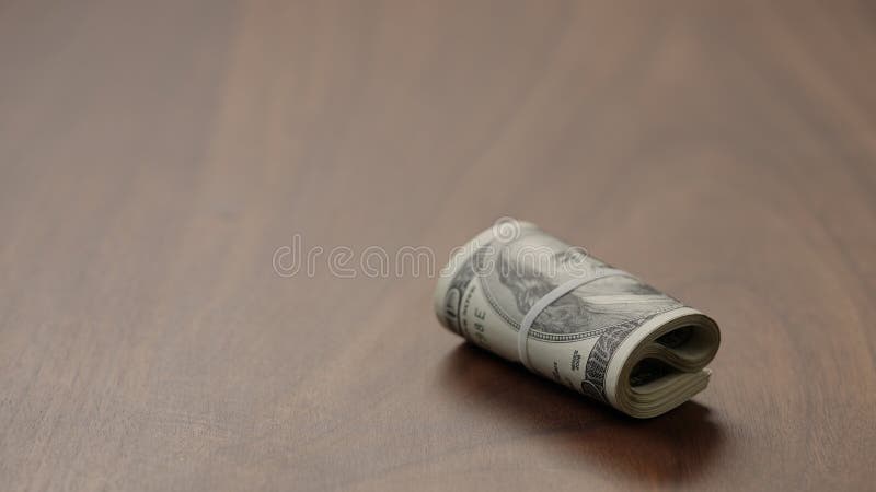 Roll of Hundred Dollar Bills on Walnut Table Shot Stock Image - Image ...