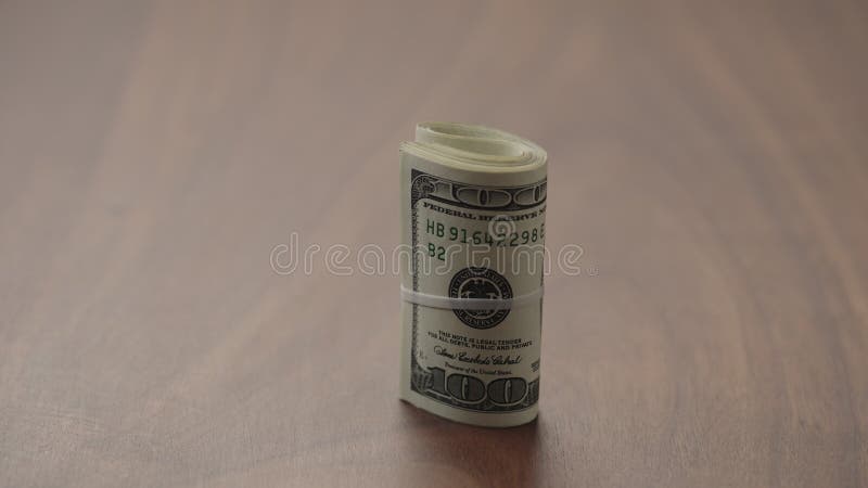 Roll of Hundred Dollar Bills on Walnut Table Slide Shot Stock Video ...