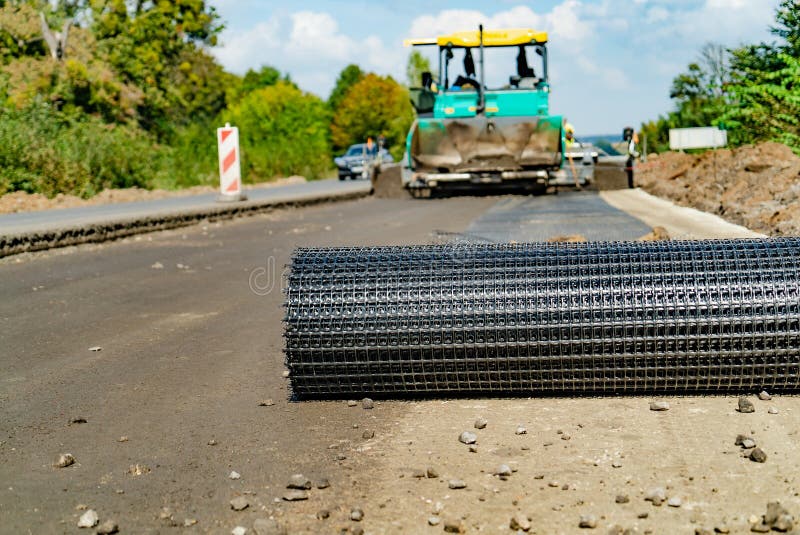 A Roll of Metal Mesh Lays on the Side of the Road on the Background of ...
