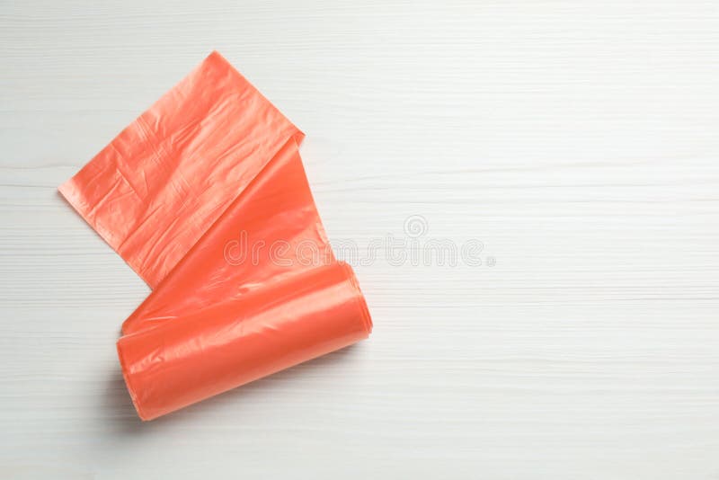 Roll of Orange Garbage Bags on White Wooden Table, Top View. Space for ...