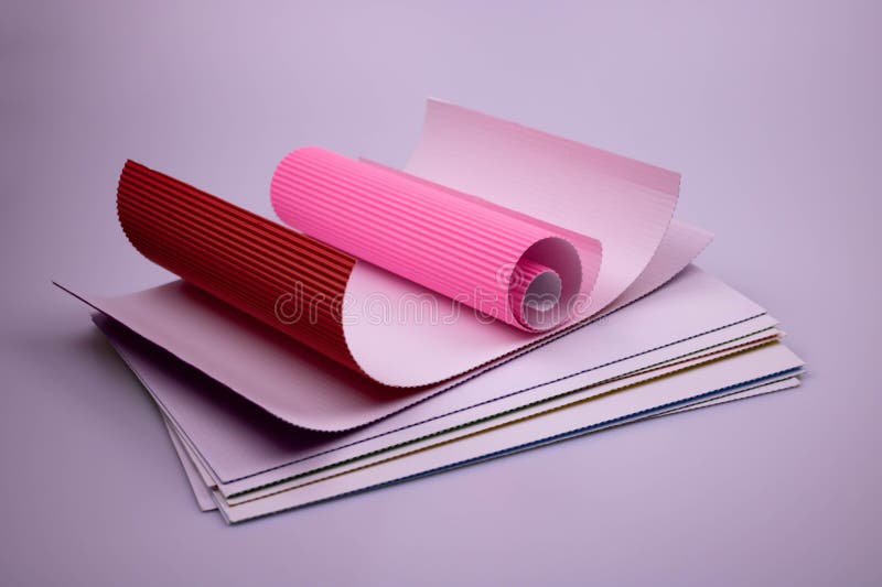 A Roll of Pink Corrugated Paper on Multicolored Leaves of Corrugated ...