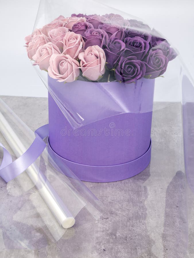 A Roll of Transparent Packaging Film and a Bouquet of Roses in a Box on ...