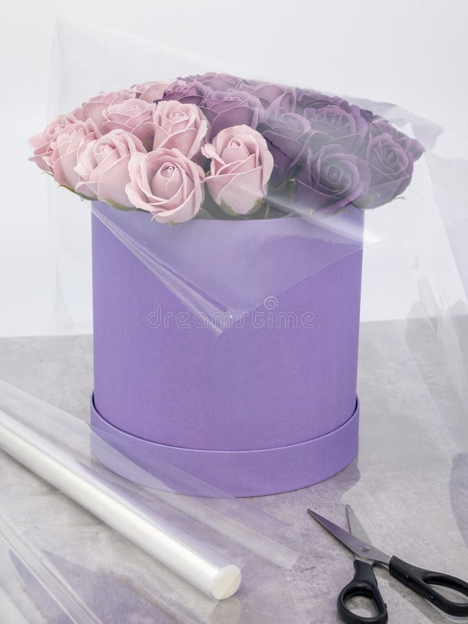 A Roll of Transparent Packaging Film and a Bouquet of Roses in a Box on ...