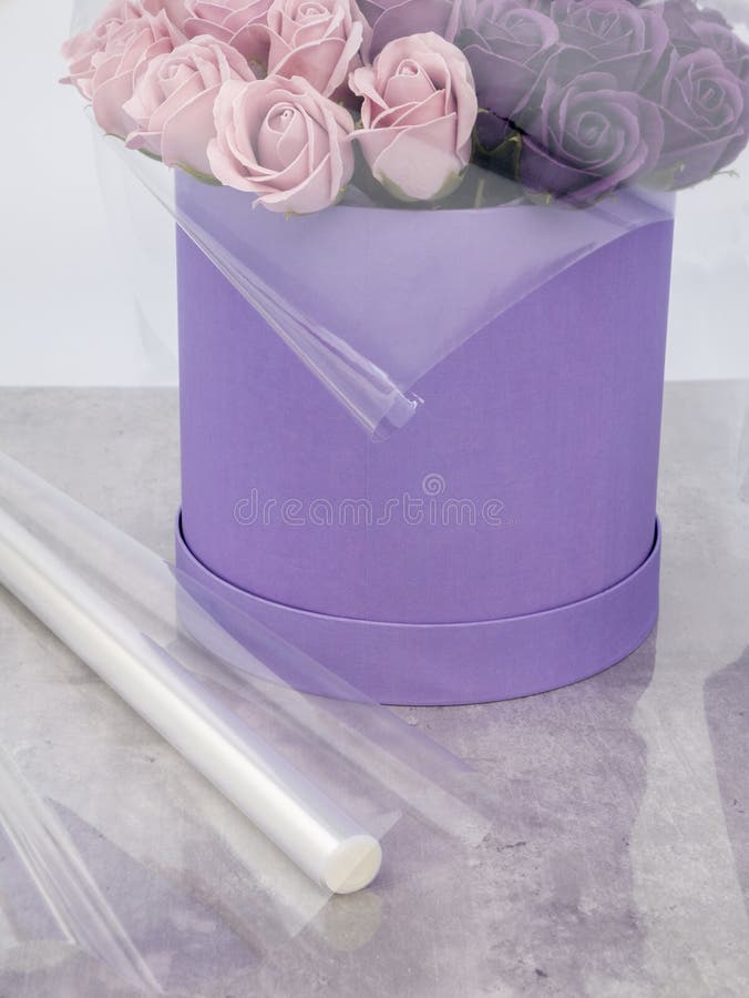 A Roll of Transparent Packaging Film and a Bouquet of Roses in a Box on ...