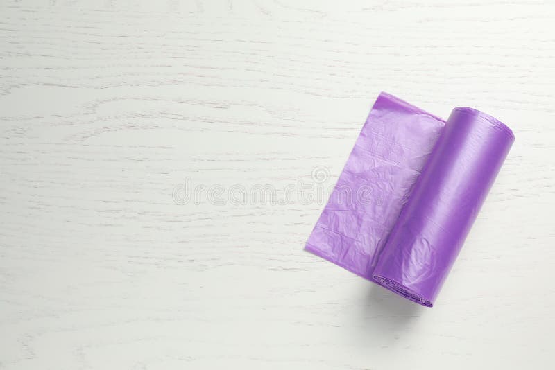 Roll of Violet Garbage Bags on White Wooden Table, Top View. Space for ...