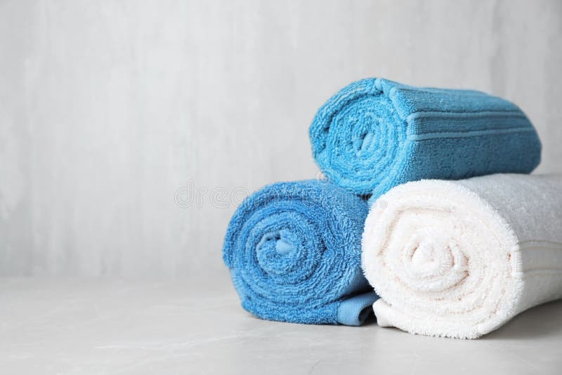 Rolled Bath Towels on Table Stock Image - Image of laundry, blue: 139943823