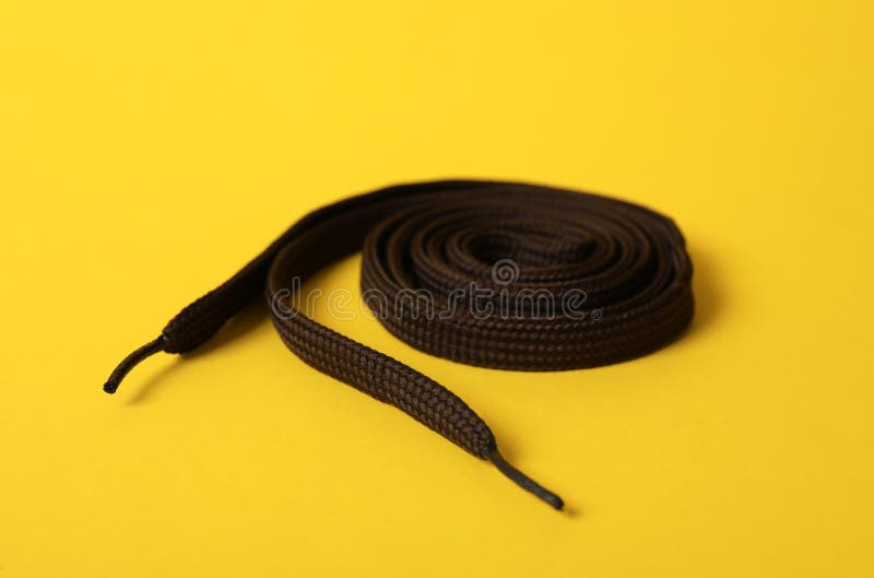 Rolled Dark Brown Shoe Lace on Yellow Background Stock Photo - Image of ...