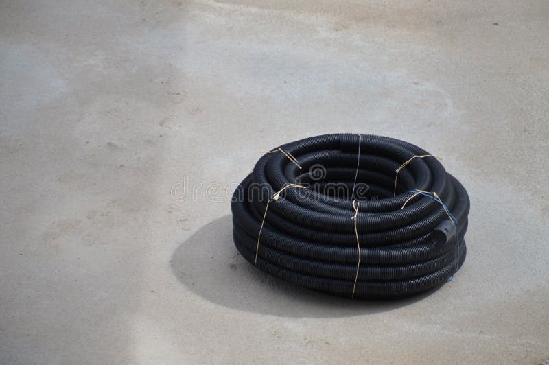 Rolled Up Black Plastic Hose Hold Together with Pieces of Rope Stock ...