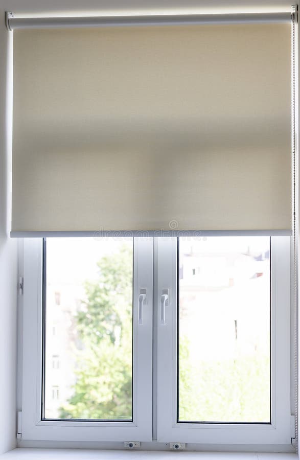 Roller Blinds Covering a Modern Window with Greenery Visible Outside ...