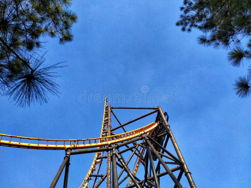 A Roller Coaster is Seen in the Distance with a Clear Blue Sky in the ...