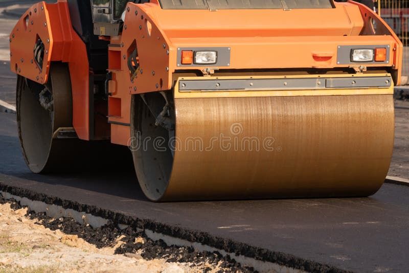 Roller Compacts Asphalt on the Road during the Construction of the Road ...