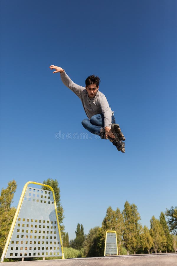 Boy with Inline Skates, Rollerblade, Doing a Jump in a Skate Park Stock ...