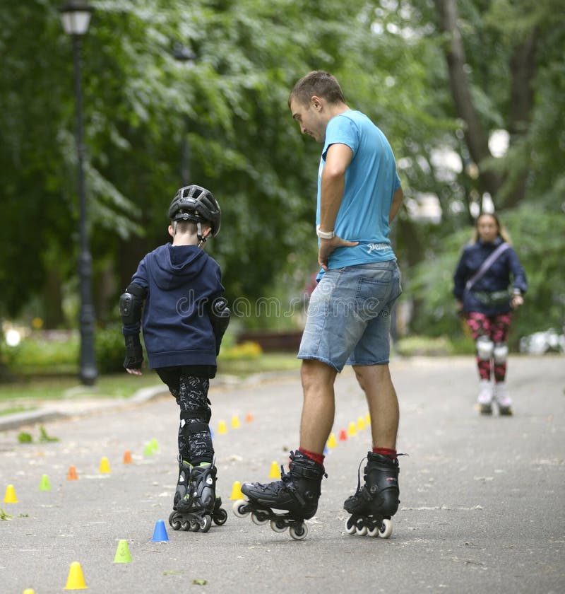 Rollerblading. Trainer Corrects Boy Movements Teaching of Artistic ...