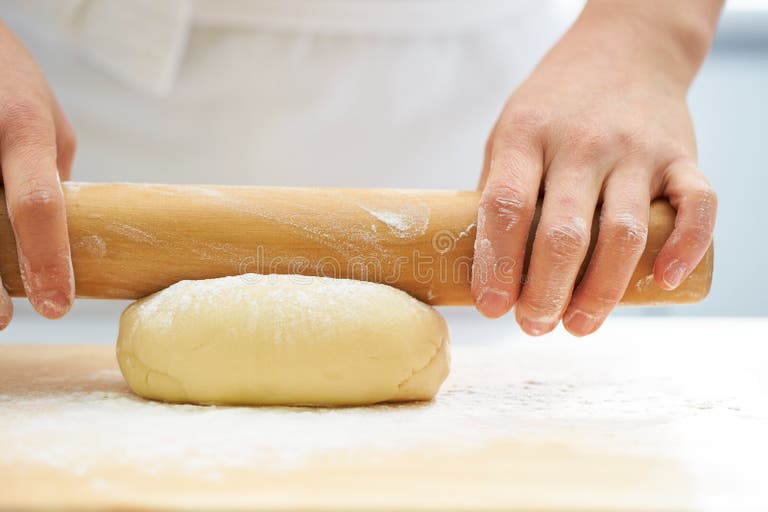 Rolling the Dough with a Rolling Pin, Bread Making Process Stock Photo ...