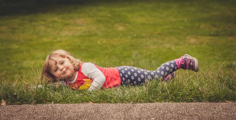 Child Rolling Down Hill in Grass Stock Photo - Image of cute, outside ...