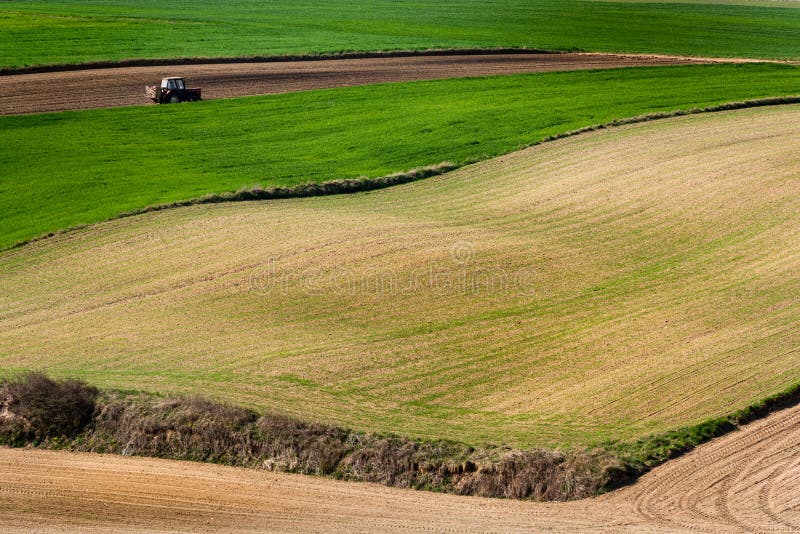 Rolling Hills at Farmland. Tractor Working in Farm at Spring Stock ...