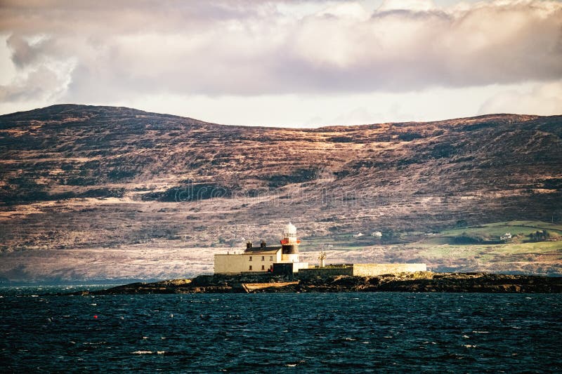 Rolling Hills Form a Dramatic Backdrop To the Lighthouse. Dark Clouds ...