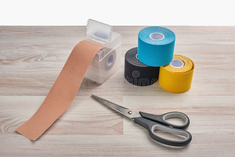 Rolls Of Colored Kinesio Tape With A Pair Of Scissors On A Wooden ...