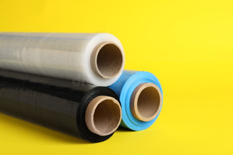 Rolls of Different Stretch Wrap on Yellow Background, Closeup Stock ...
