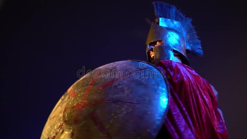 Roman Gladiator in Leather Armor, Helmet and Red Raincoat is Covered ...