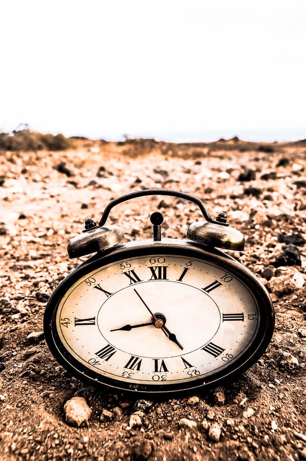 A Roman Numeral Clock is Sitting on the Ground in a Desert Stock Photo ...