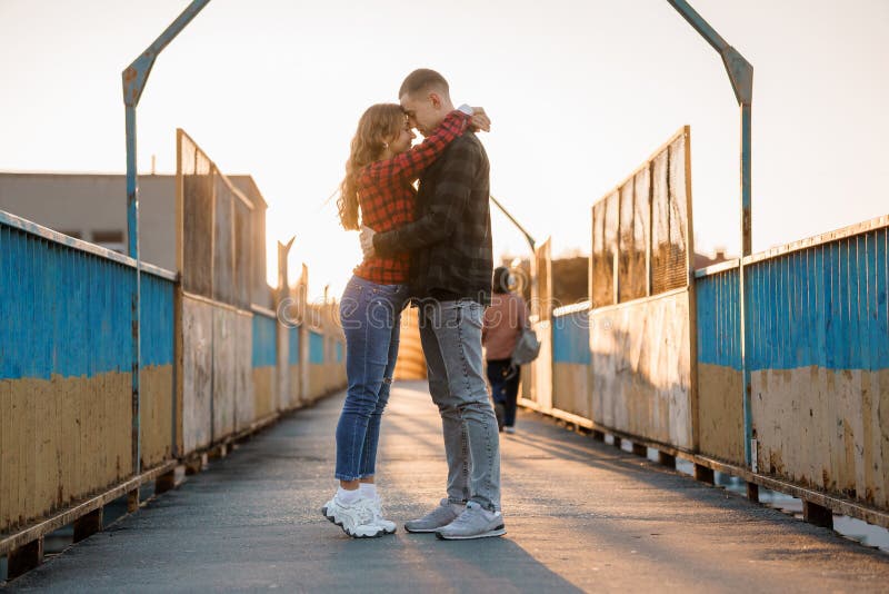 Romantic Couple Embracing on a Sunset-lit Bridge Stock Image - Image of ...