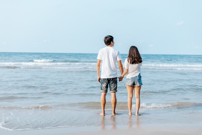 Romantic Couple Holding Hands And Stand Together On Beach Man And