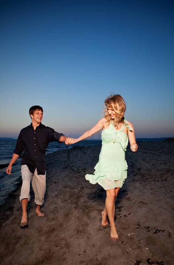 Happy Couple of Man and Woman Run Along the Shore Holding Hands. Stock ...