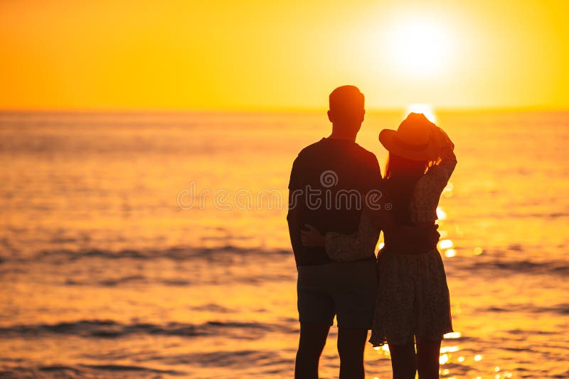 Romantic Couple On The Beach At Colorful Sunset On Background Stock