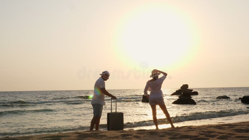 Romantic Couple Of Lovers Silhouettes Travelers Walk Along The Beach