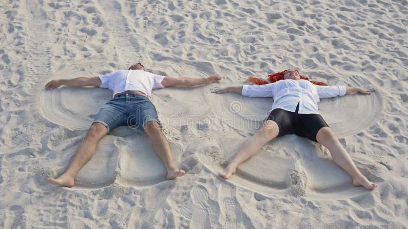 Romantic Couple Making SAND ANGELS. Good Mood Stock Video - Video of ...