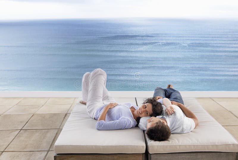 Romantic Couple Relaxing on Sunbeds by Infinity Pool Stock Photo ...