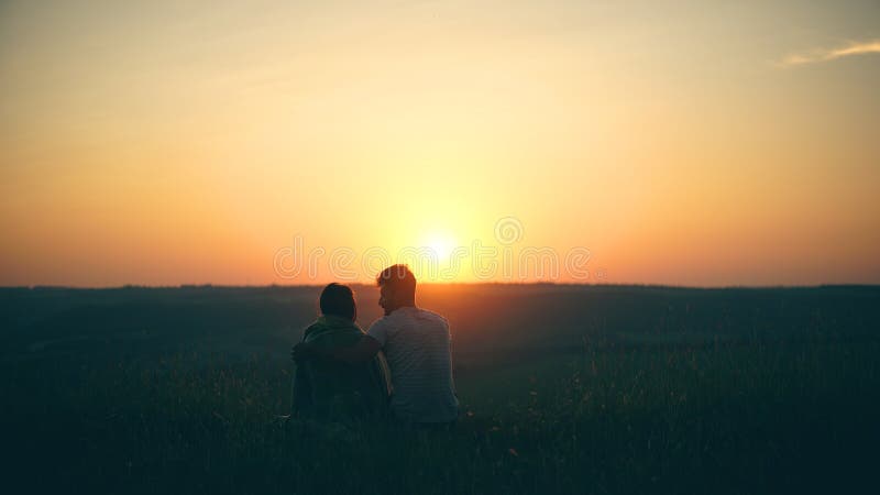 The Romantic Couple Watching the Beautiful Sunset View. Stock Photo ...
