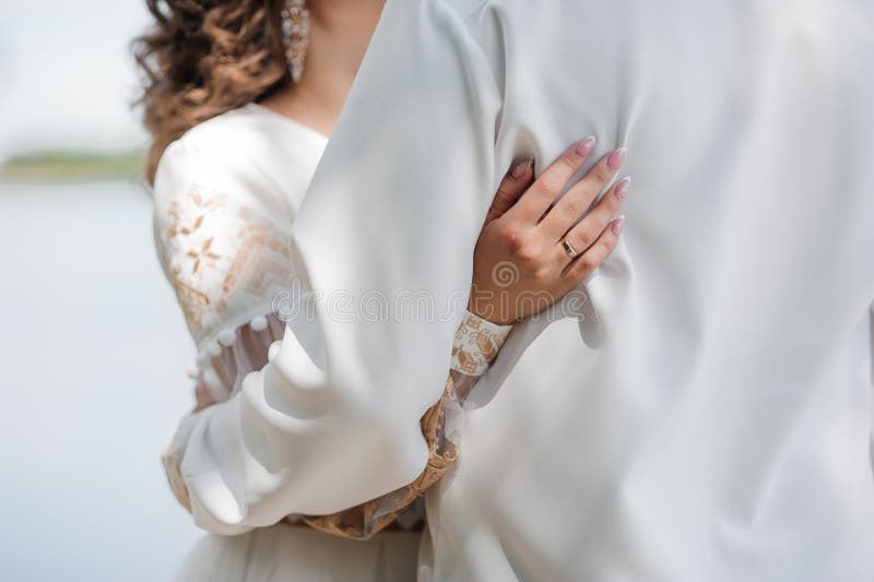 Romantic Embrace of a Couple by the Water in a Sunlit Setting Stock ...
