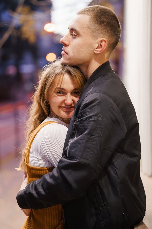 Romantic Embrace of a Young Couple Under Soft City Lights Stock Image - Image of romance ...