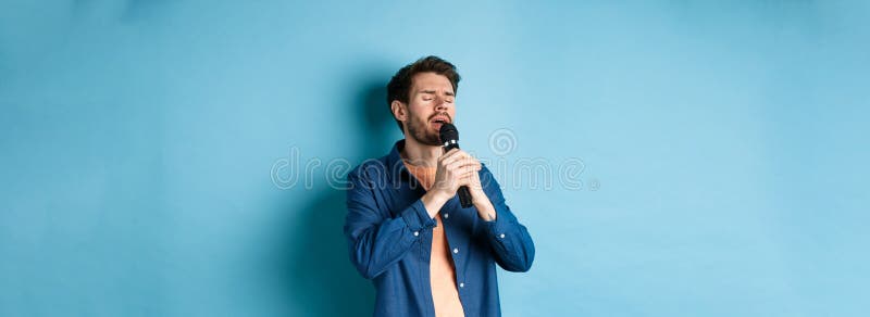 Romantic Guy Singing in Microphone, Performing on Stage, Standing on ...