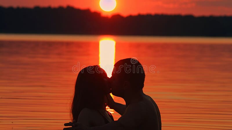 Romantic Kiss in the Water on a Background Sunset Stock Image - Image ...