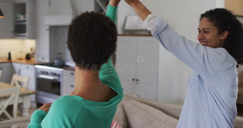 Romantic Mixed Race Lesbian Couple Dancing In Sitting Room Stock