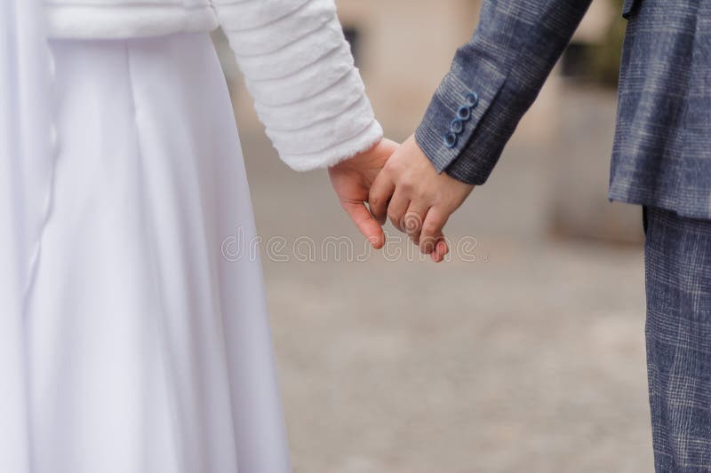 Romantic Moment of a Couple Holding Hands in Elegant Attire Stock Photo ...
