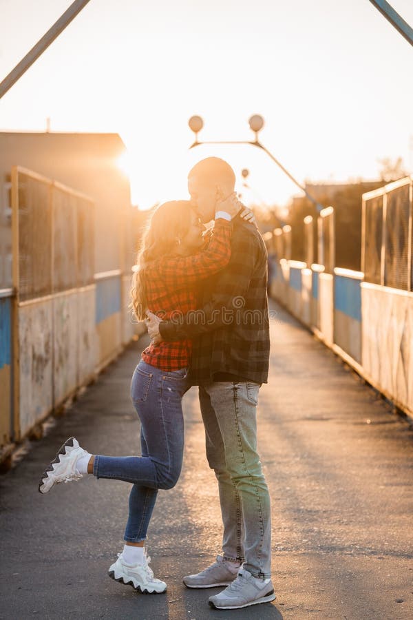Romantic Sunset Embrace of a Happy Young Couple on a Bridge Stock Image ...